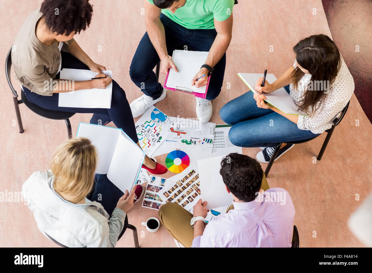 Students sitting in circle working together Stock Photo - Alamy