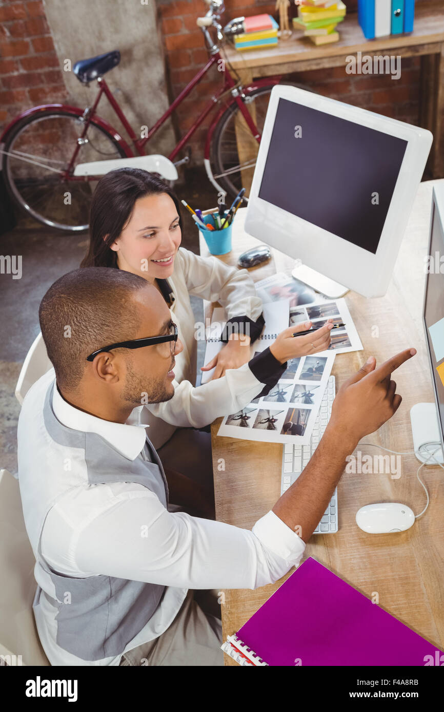 Colleagues discussing while looking at computer Stock Photo - Alamy
