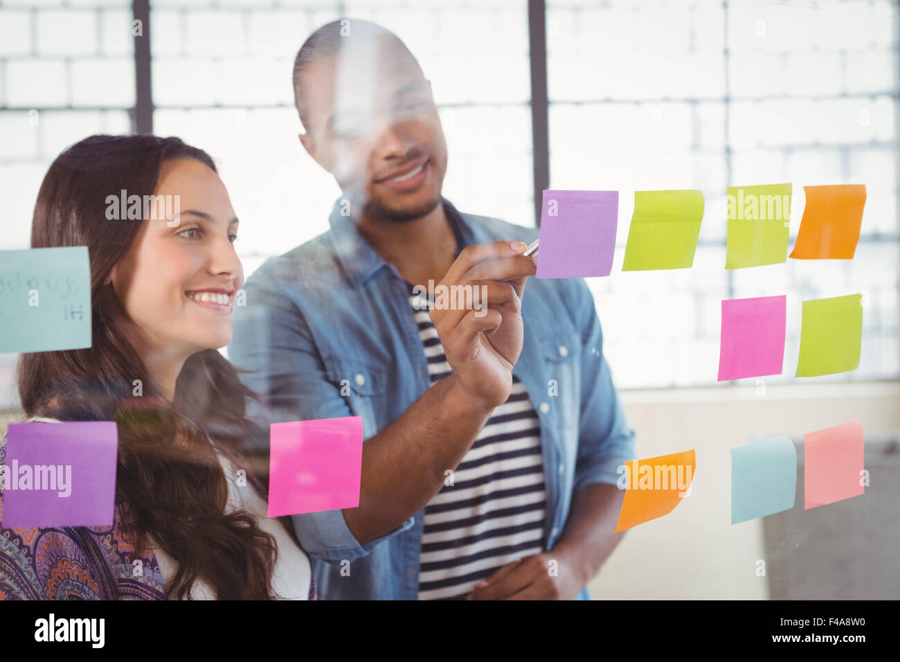 Man writing on sticky note at office Stock Photo - Alamy