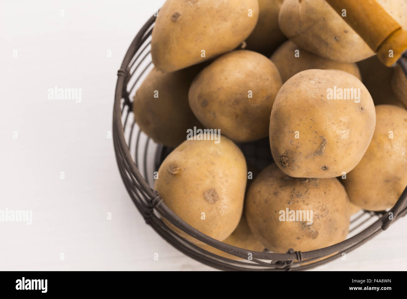 uncooked potatoes in wire basket Stock Photo - Alamy