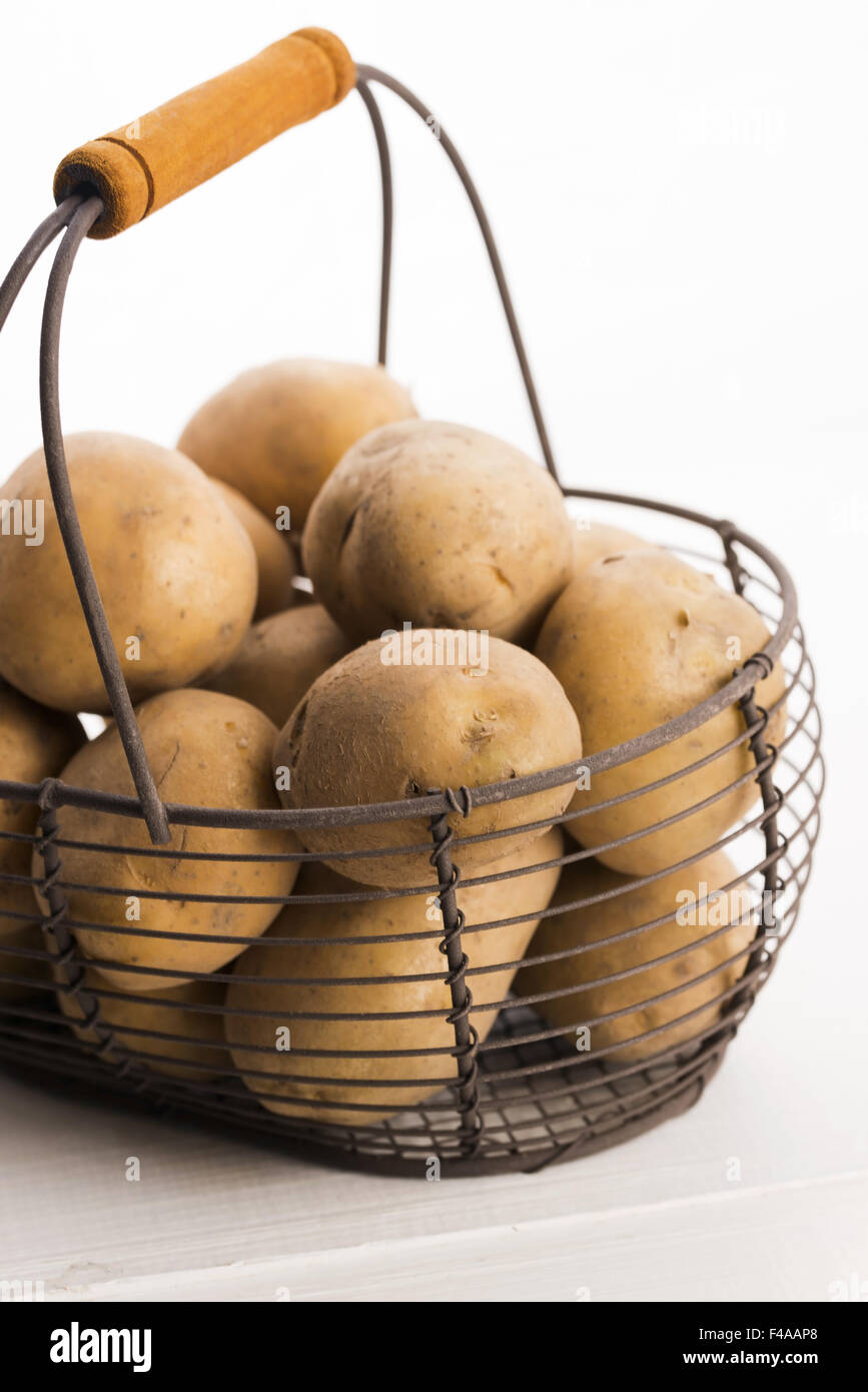 uncooked potatoes in wire basket Stock Photo - Alamy