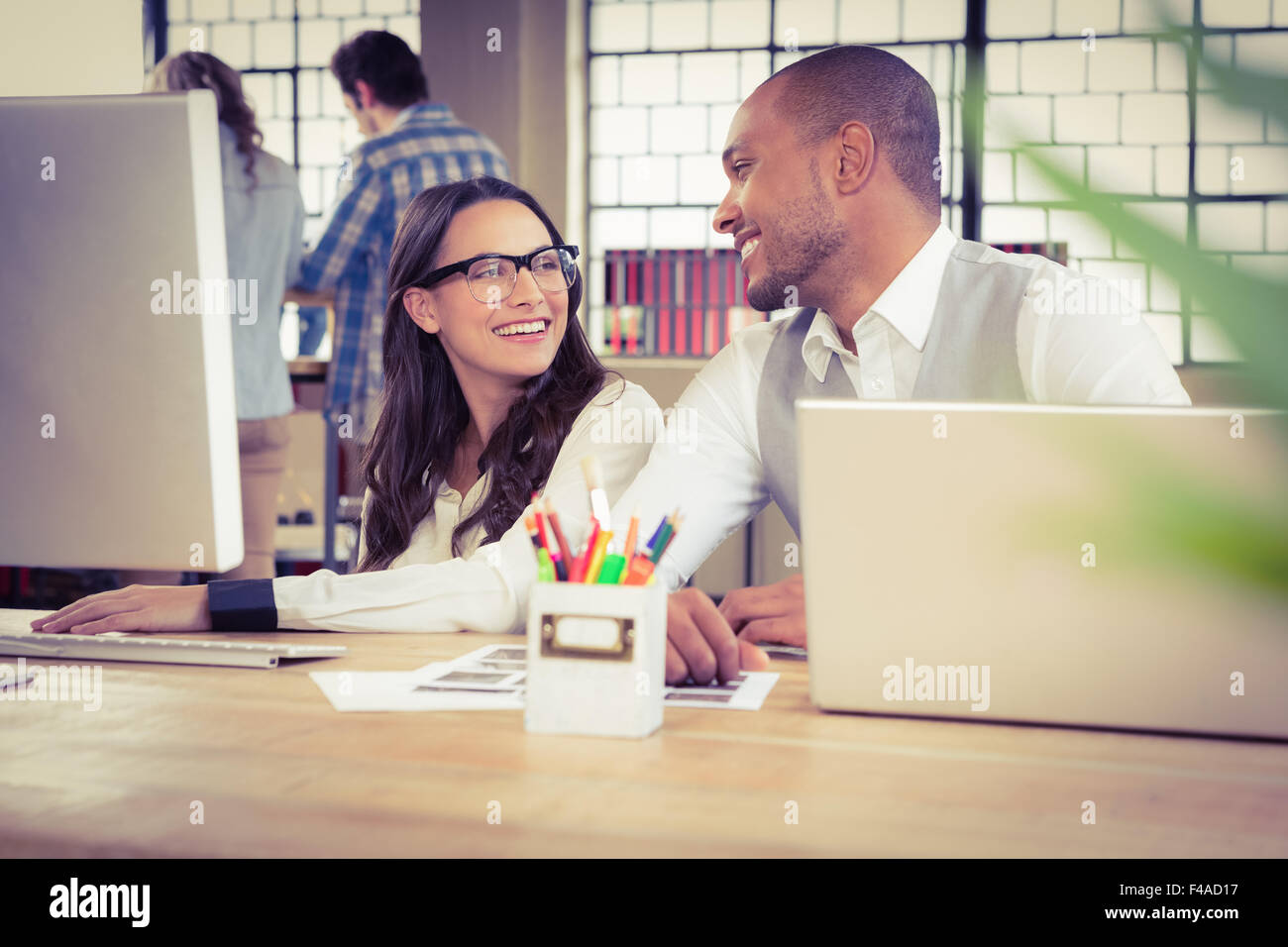 Colleagues laughing at office Stock Photo - Alamy