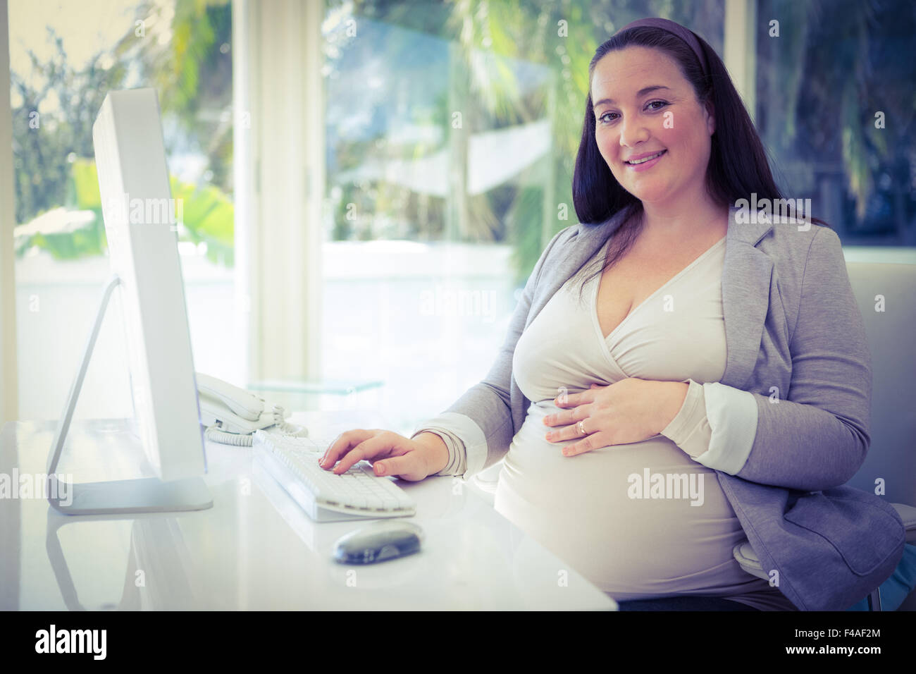 Pregnant businesswoman working on her computer Stock Photo - Alamy