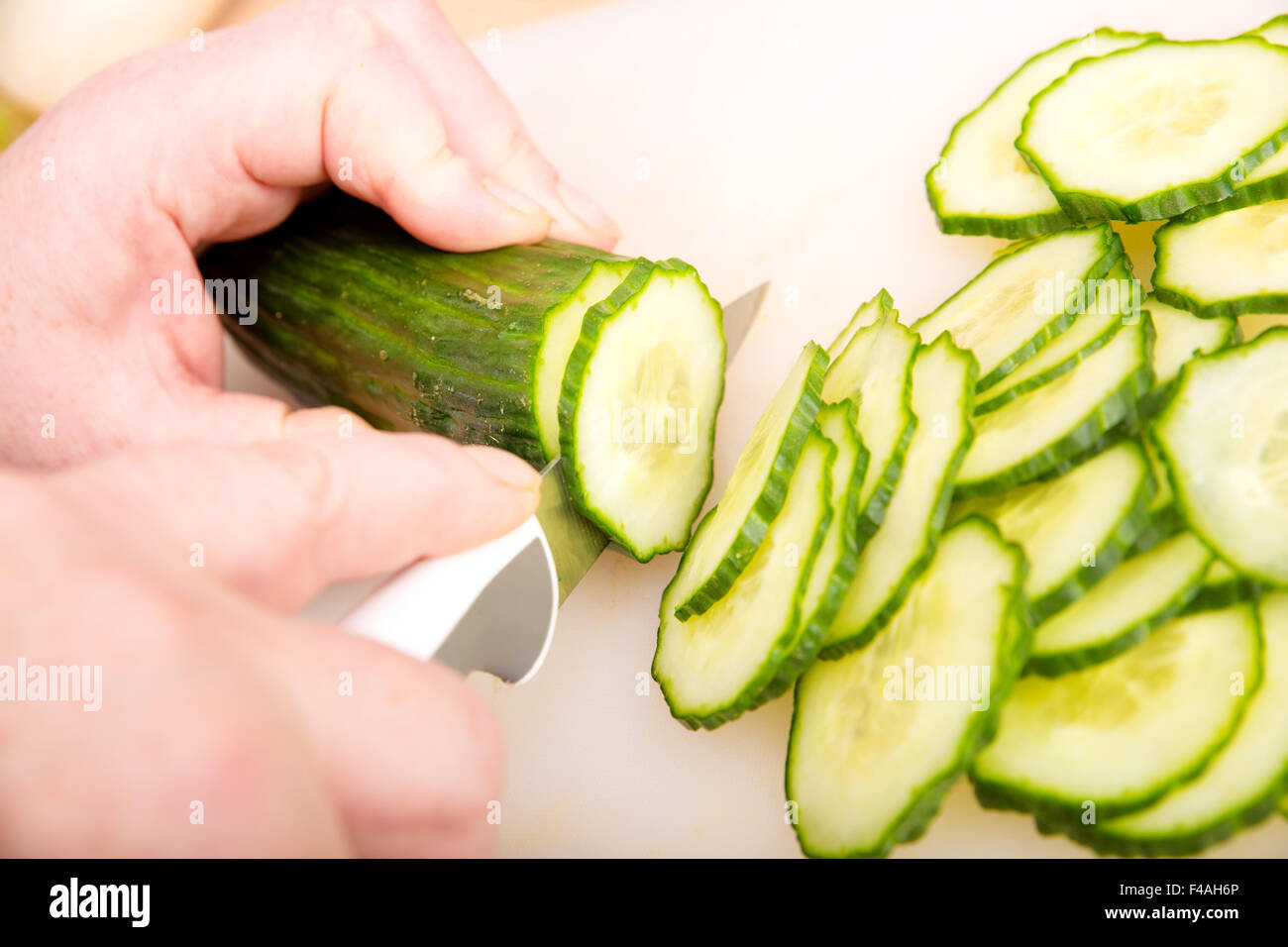 Woman cutting cucumber Stock Photo - Alamy