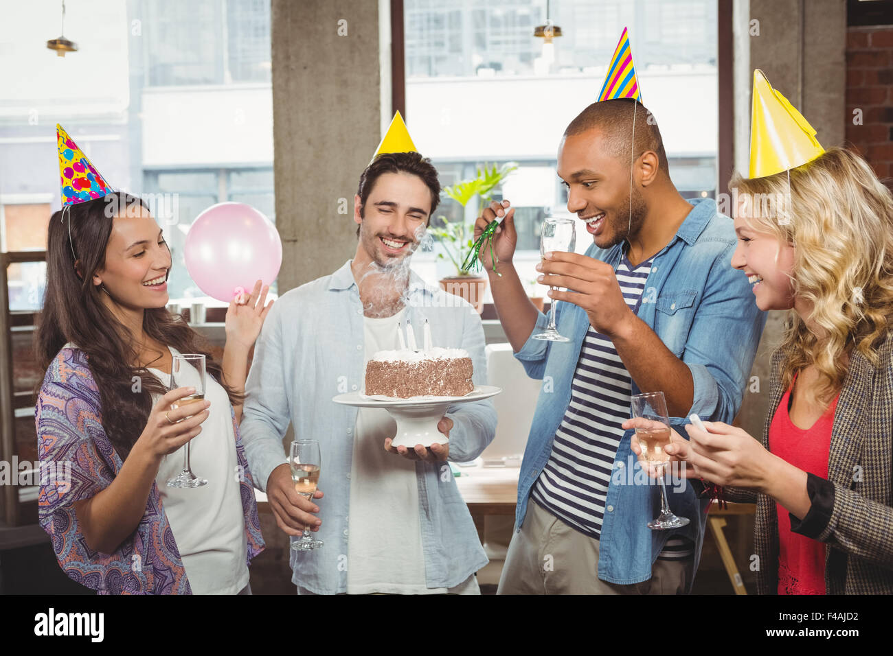 Happy colleagues looking at birthday cake Stock Photo - Alamy