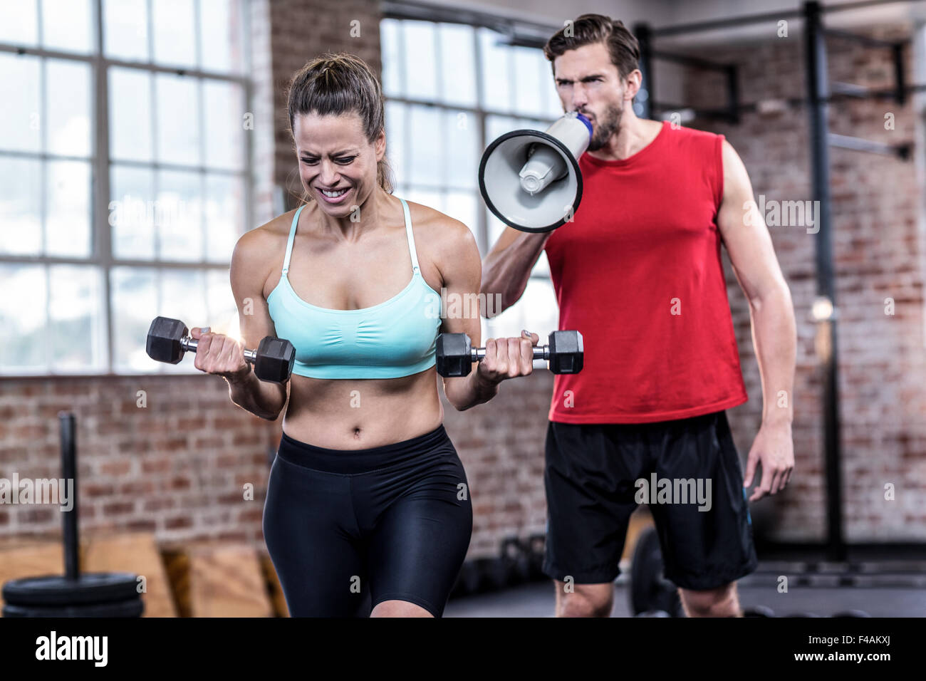 Coach motivating woman lifting dumbbells Stock Photo - Alamy