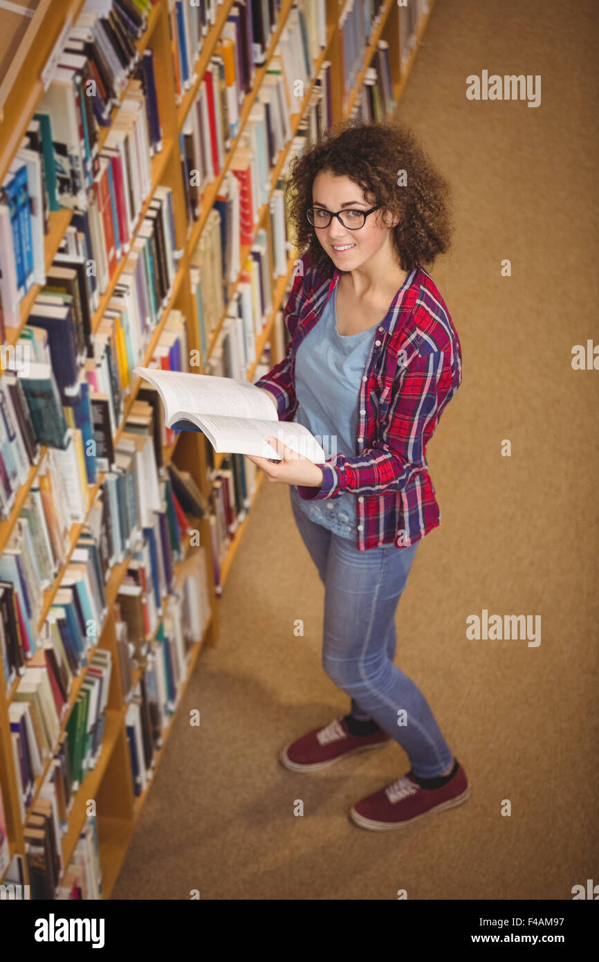 Pretty student in library taking book Stock Photo - Alamy