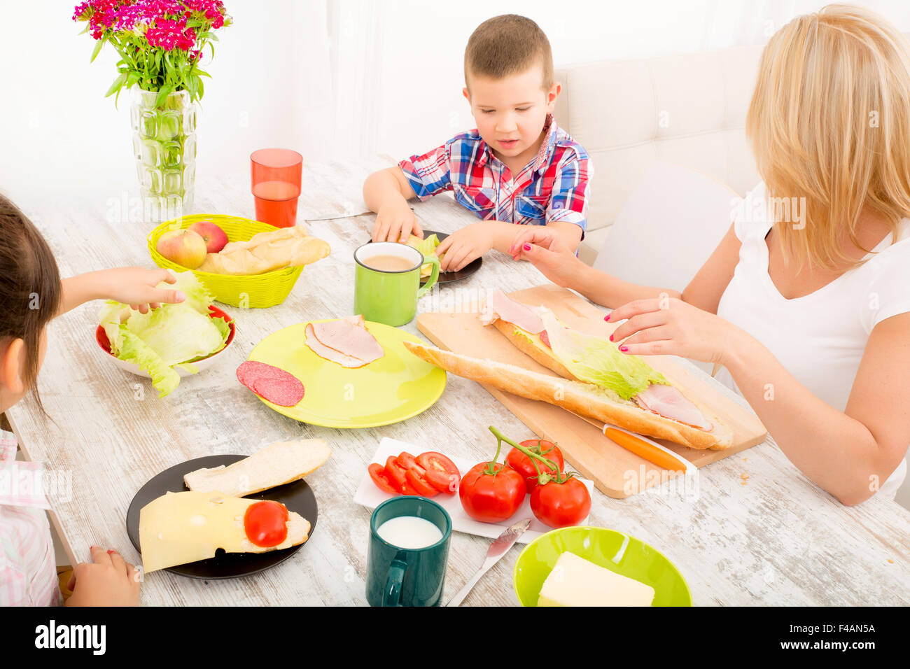 Happy family having breakfast at home Stock Photo - Alamy