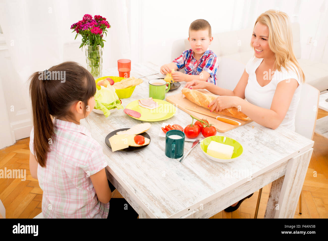 Happy family having breakfast at home Stock Photo - Alamy