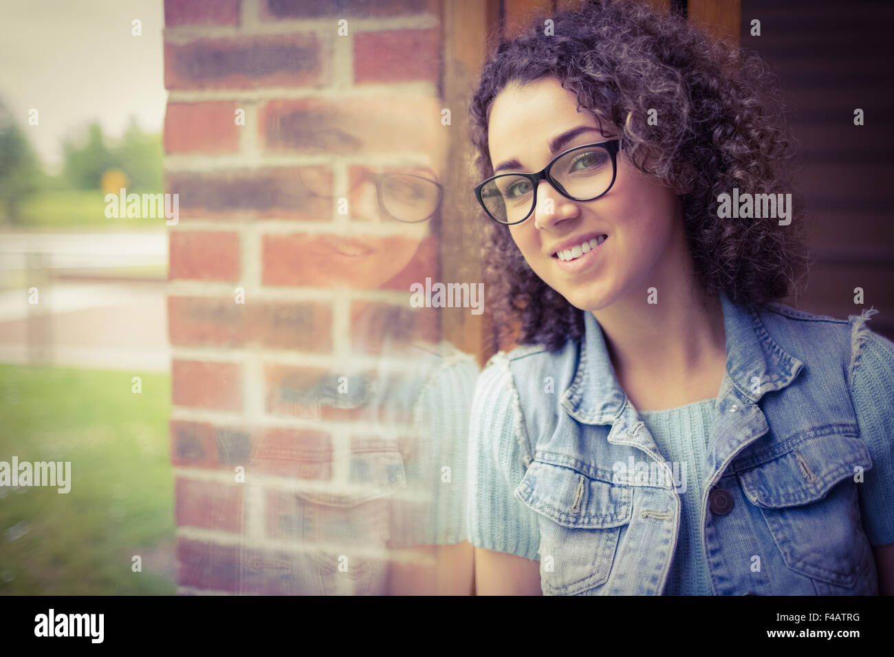 Pretty student sitting by window smiling at camera Stock Photo - Alamy