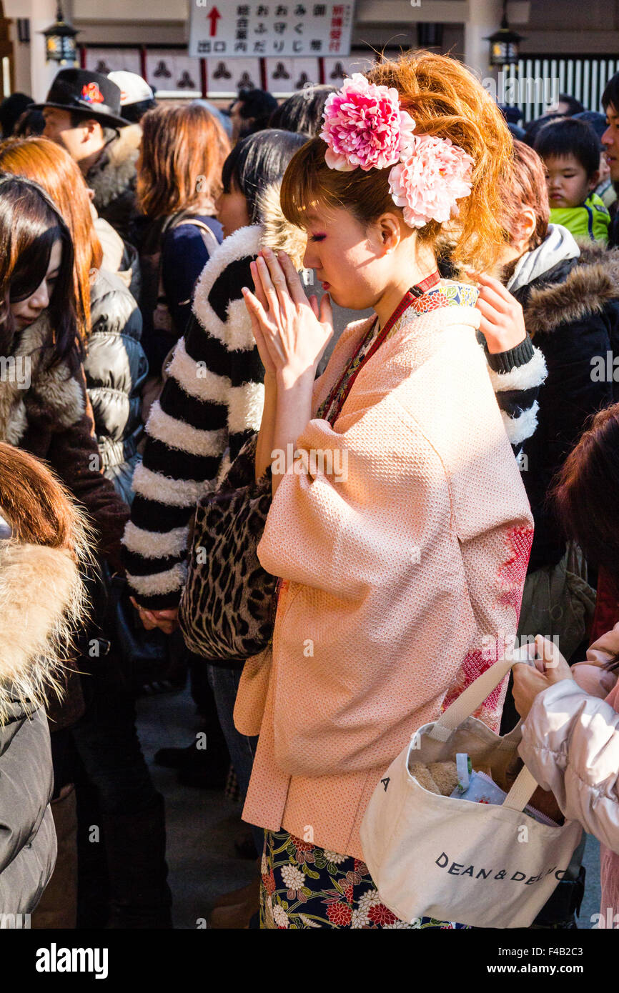 Japan, Nishinomiya shrine, New Year. Side view of young woman, in crowd ...