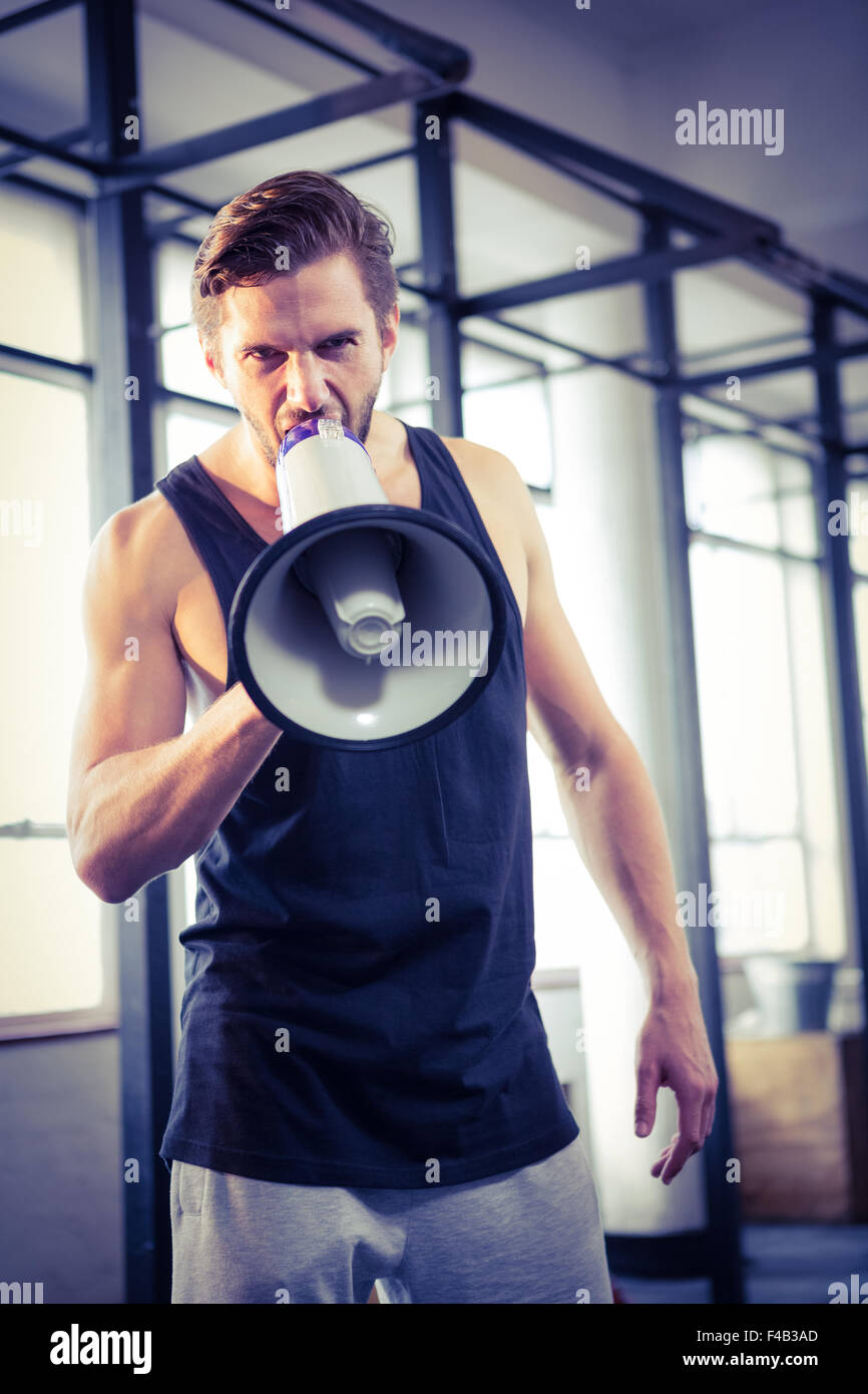 Fit trainer shouting through megaphone Stock Photo - Alamy