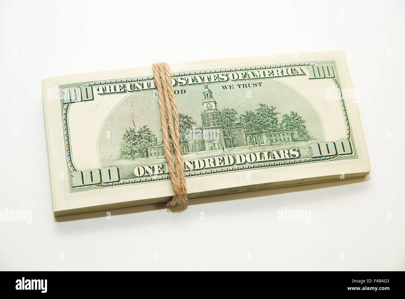 One pack of dollars tied up with rope on over white Stock Photo - Alamy