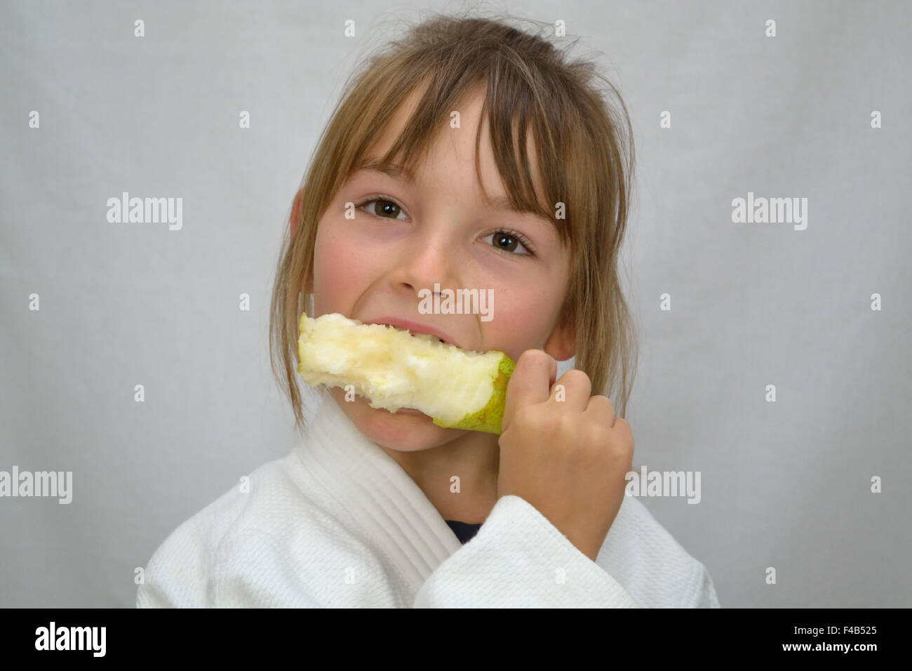 little girl biting pear Stock Photo - Alamy