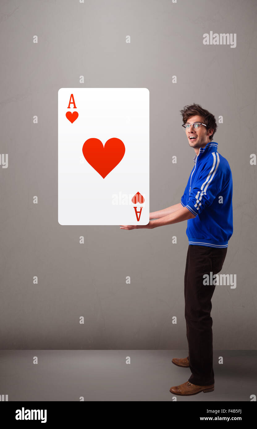 Young man holding a red heart ace Stock Photo - Alamy