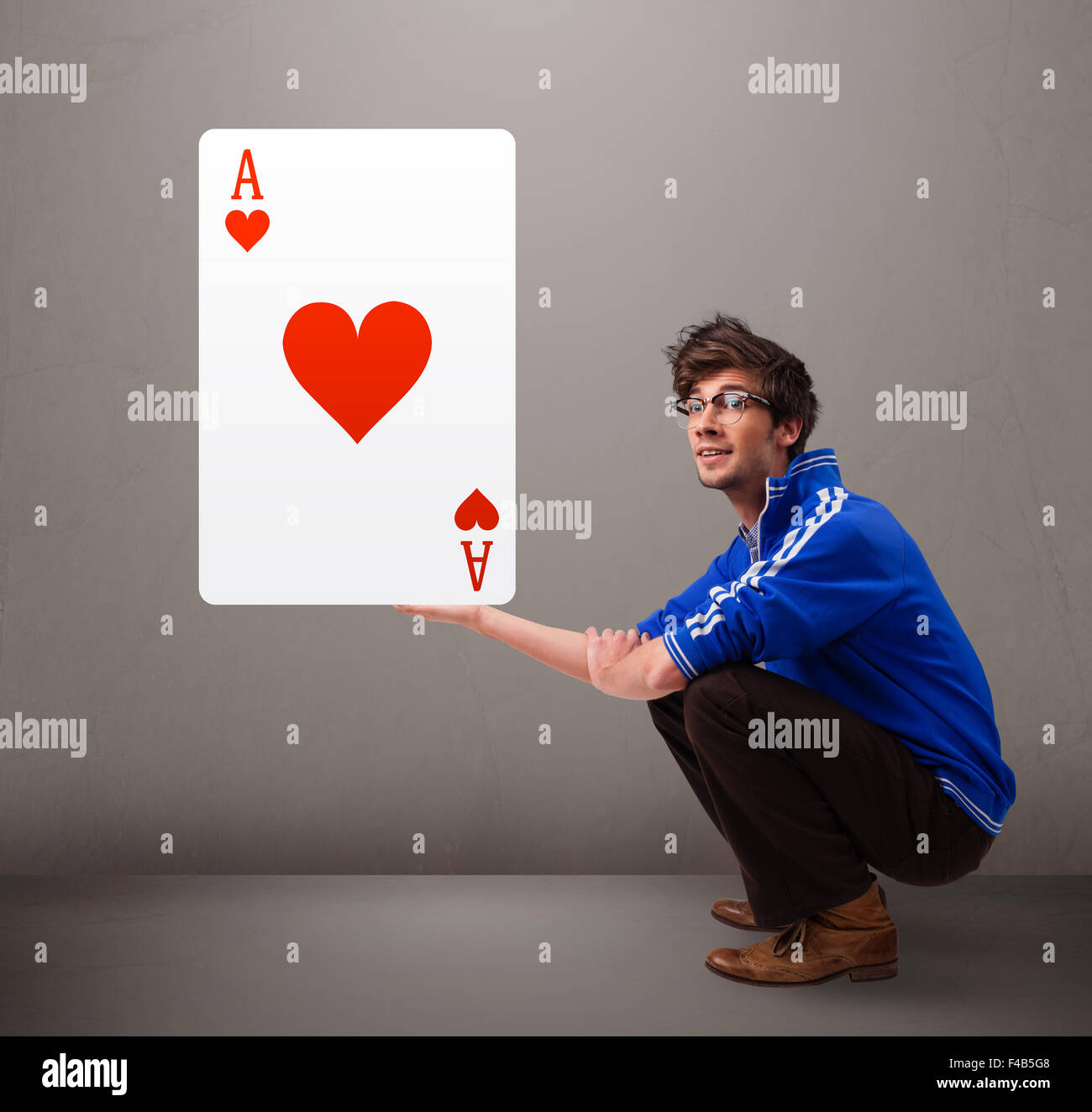 Young man holding a red heart ace Stock Photo - Alamy