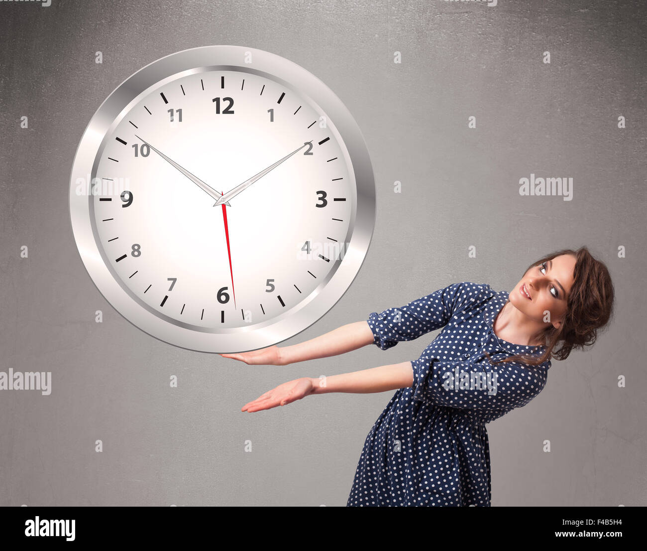 Attractive lady holding a huge clock Stock Photo - Alamy