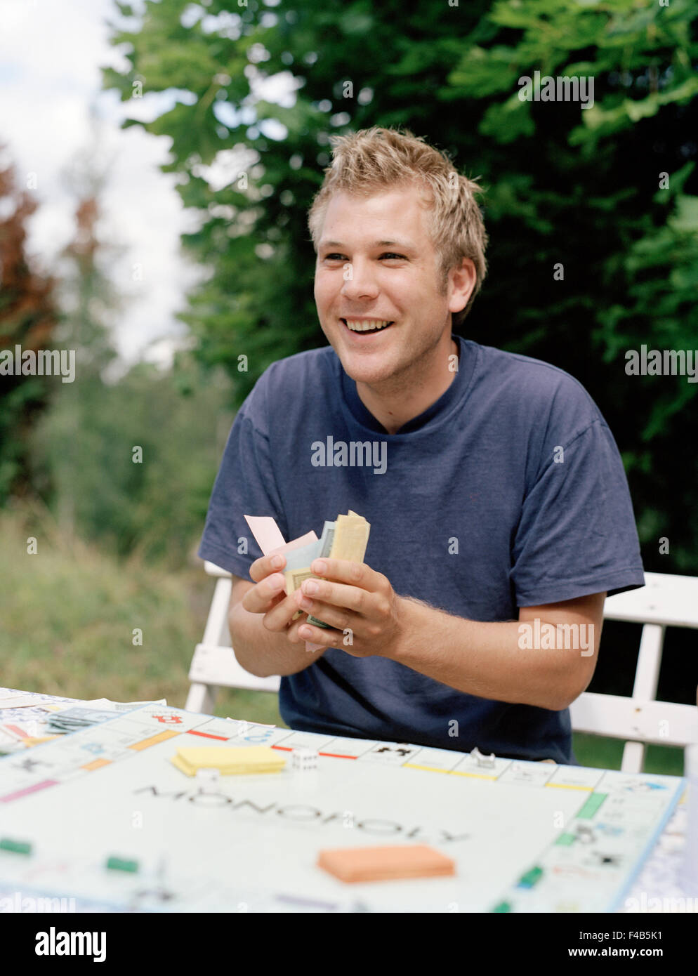 A smiling guy playing monopoly Stock Photo - Alamy
