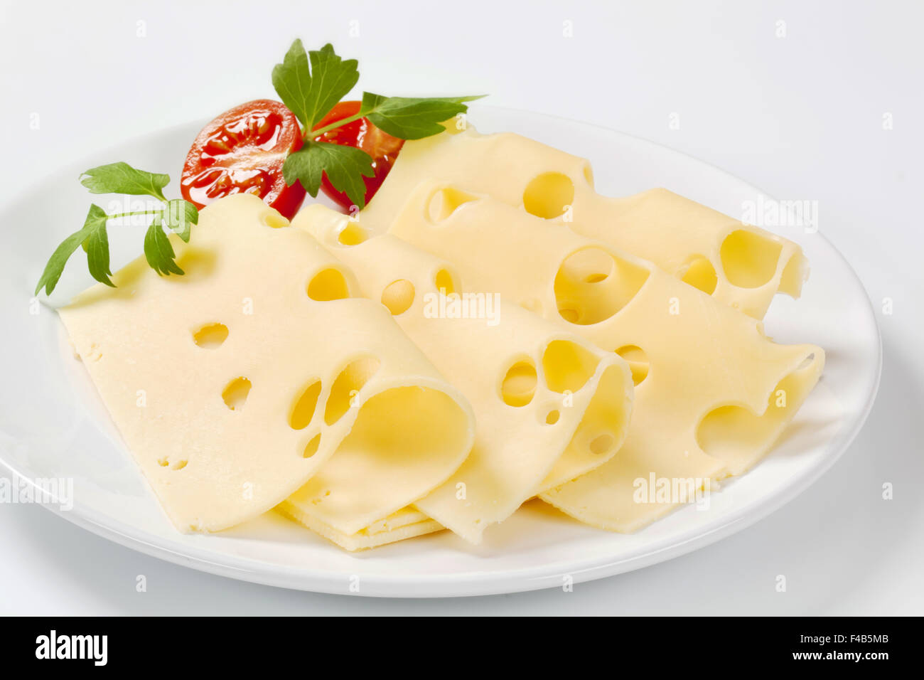 thin slices of emmental cheese on white plate Stock Photo - Alamy