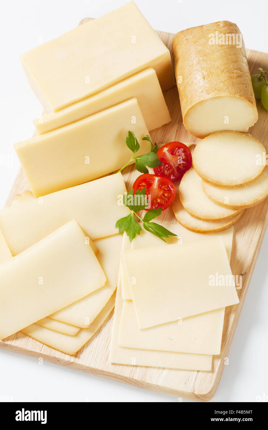 variety of sliced cheeses on cutting board Stock Photo - Alamy