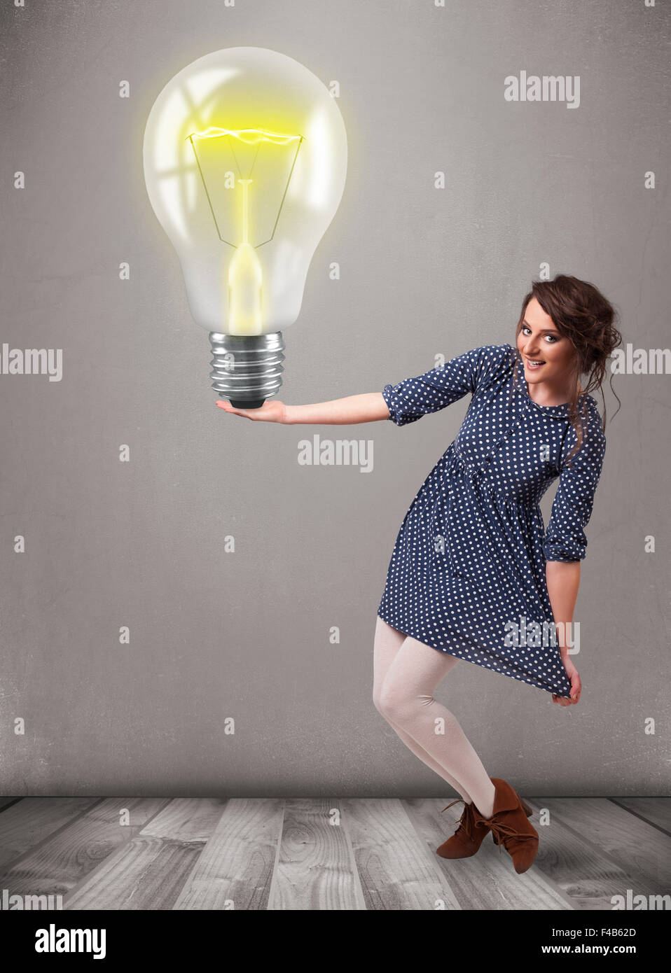 Beautiful lady holding realistic 3d light bulb Stock Photo - Alamy