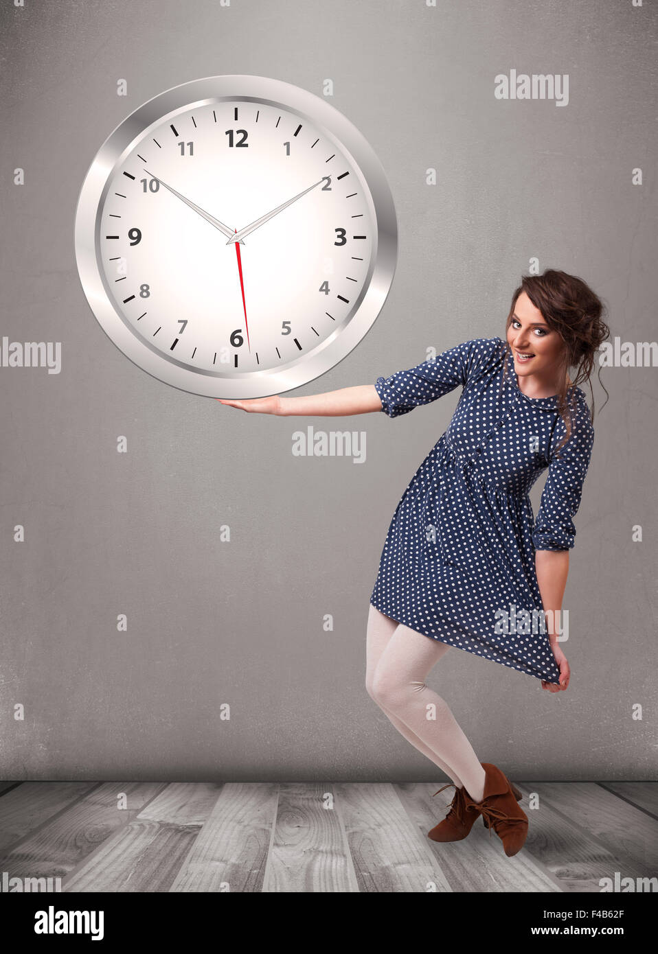 Attractive lady holding a huge clock Stock Photo - Alamy