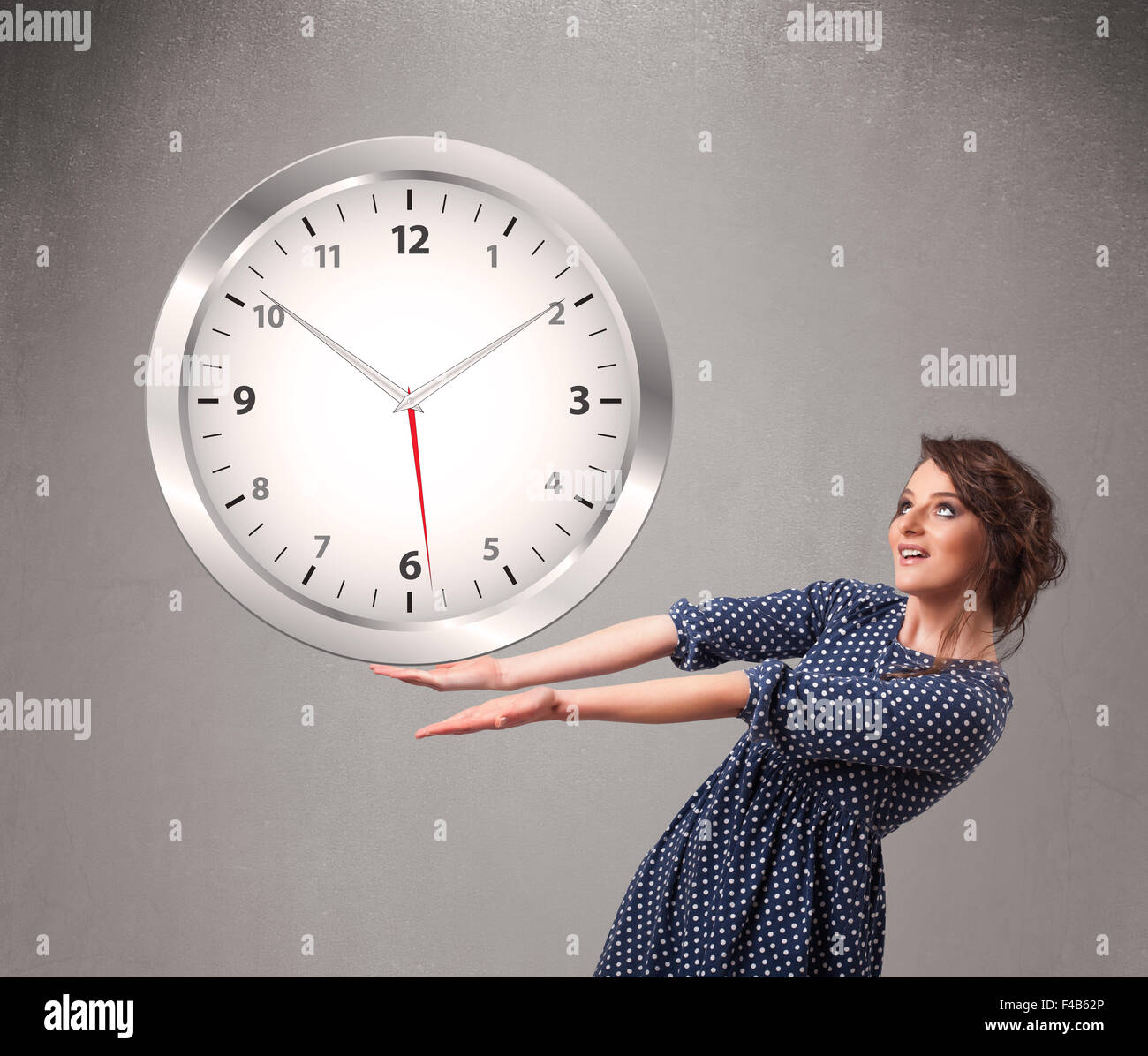 Attractive lady holding a huge clock Stock Photo - Alamy