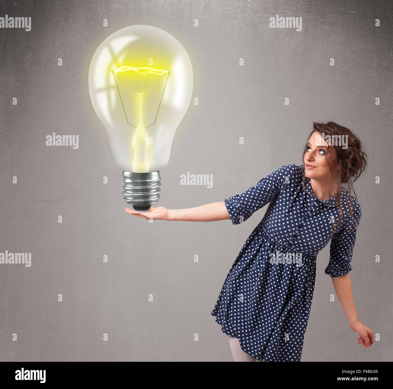 Beautiful lady holding realistic 3d light bulb Stock Photo - Alamy