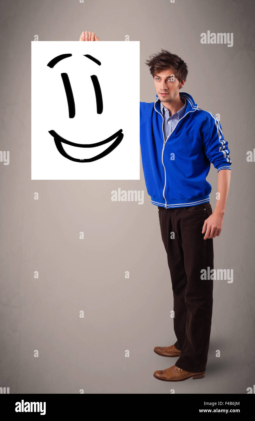 Young boy holding smiley face drawing Stock Photo - Alamy