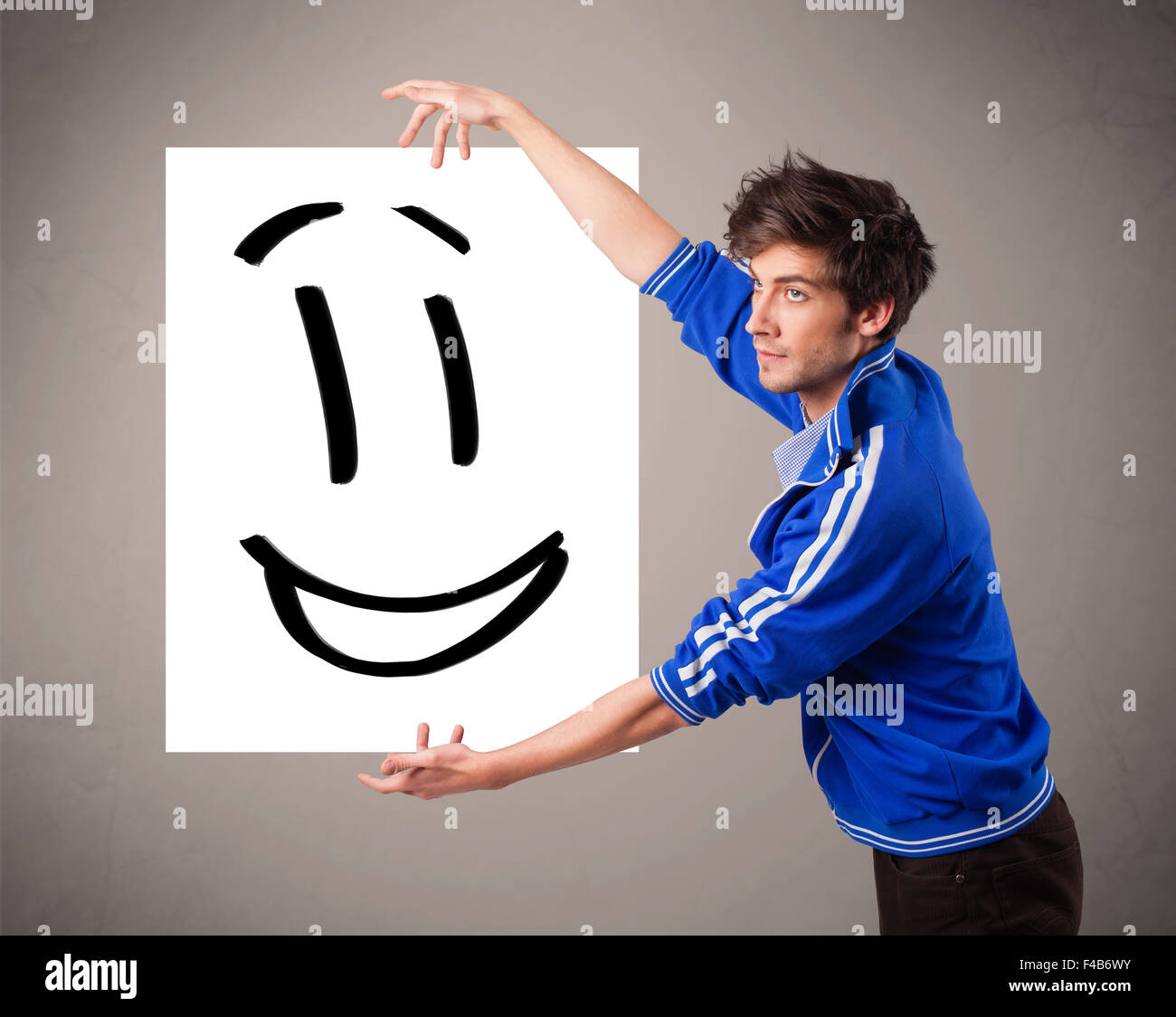 Young boy holding smiley face drawing Stock Photo - Alamy