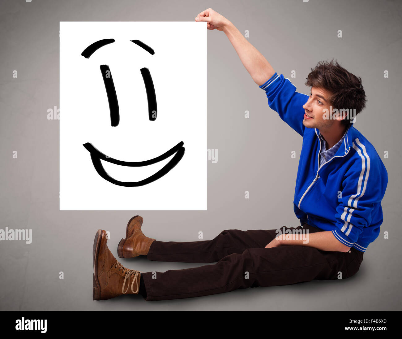 Young boy holding smiley face drawing Stock Photo - Alamy