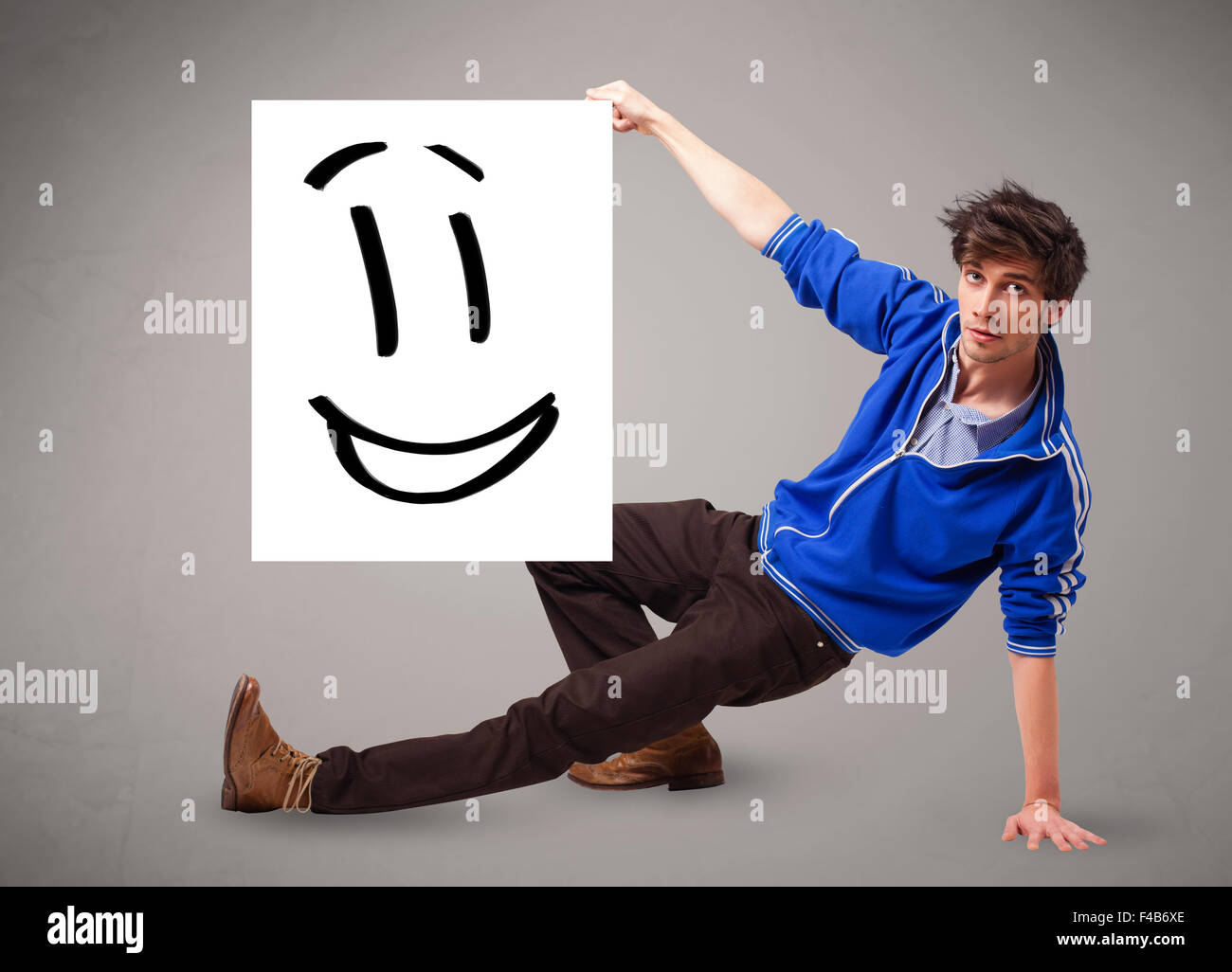 Young boy holding smiley face drawing Stock Photo - Alamy