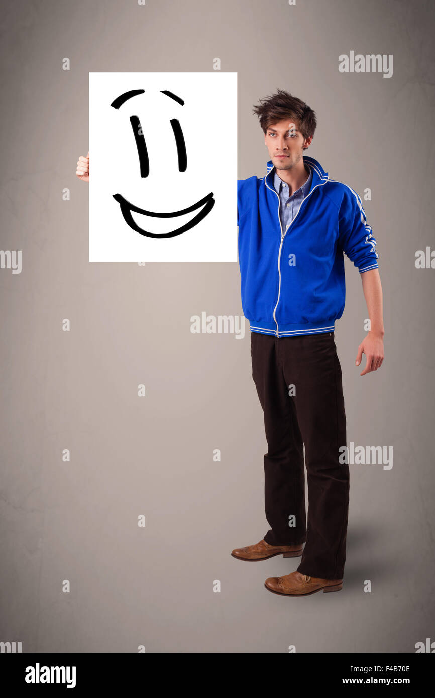 Young boy holding smiley face drawing Stock Photo - Alamy