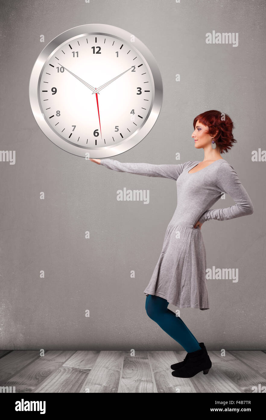 Attractive lady holding a huge clock Stock Photo - Alamy