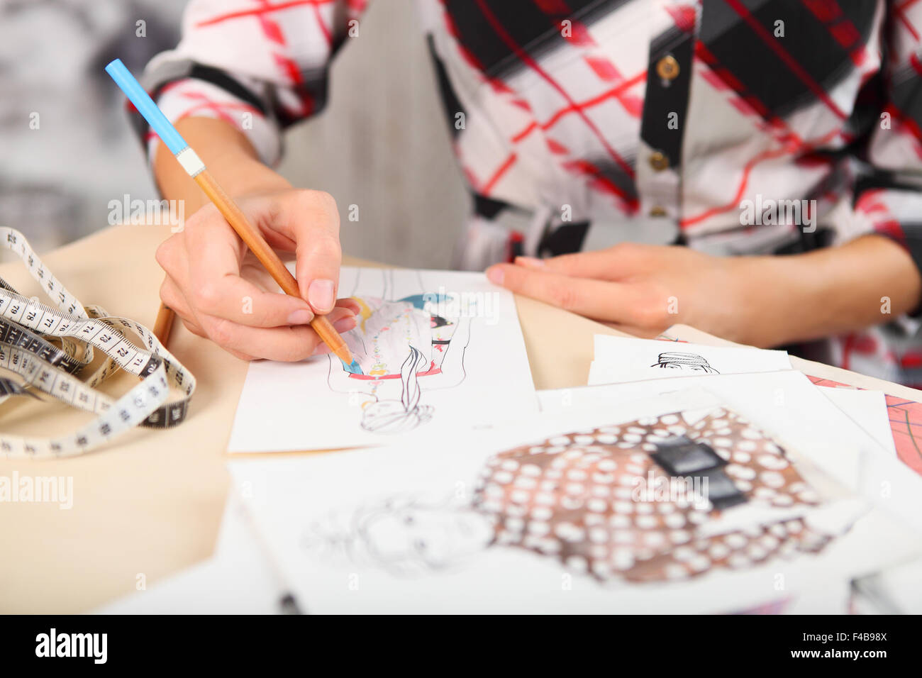 Dressmaker is drawing a fashion sketch Stock Photo - Alamy