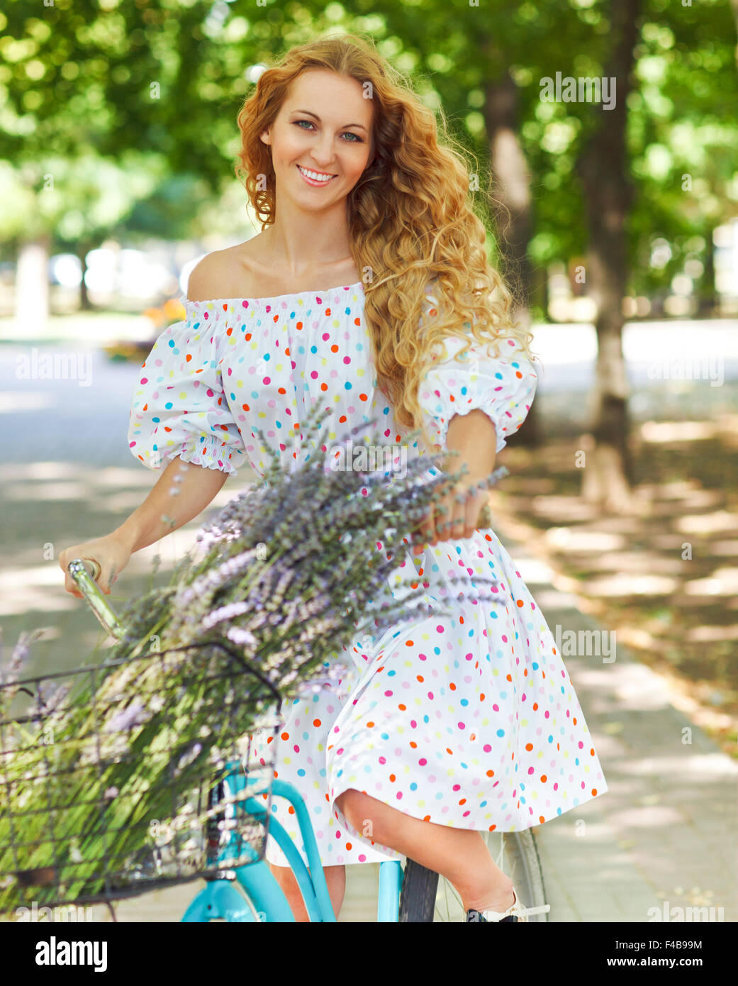 Beautiful and happy young woman on bicycle Stock Photo - Alamy