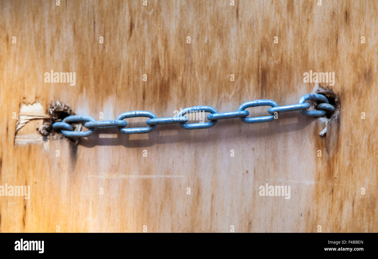 Chain through wooden board background concept Stock Photo - Alamy