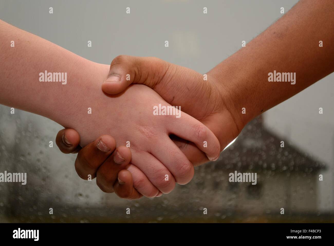 Handshake of different colored teenager Stock Photo - Alamy