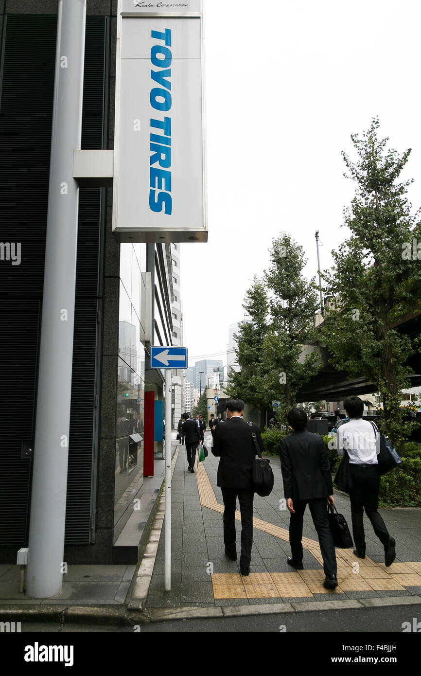 Pedestrians walk past the Toyo Tire & Rubber Co. building on October 16 ...