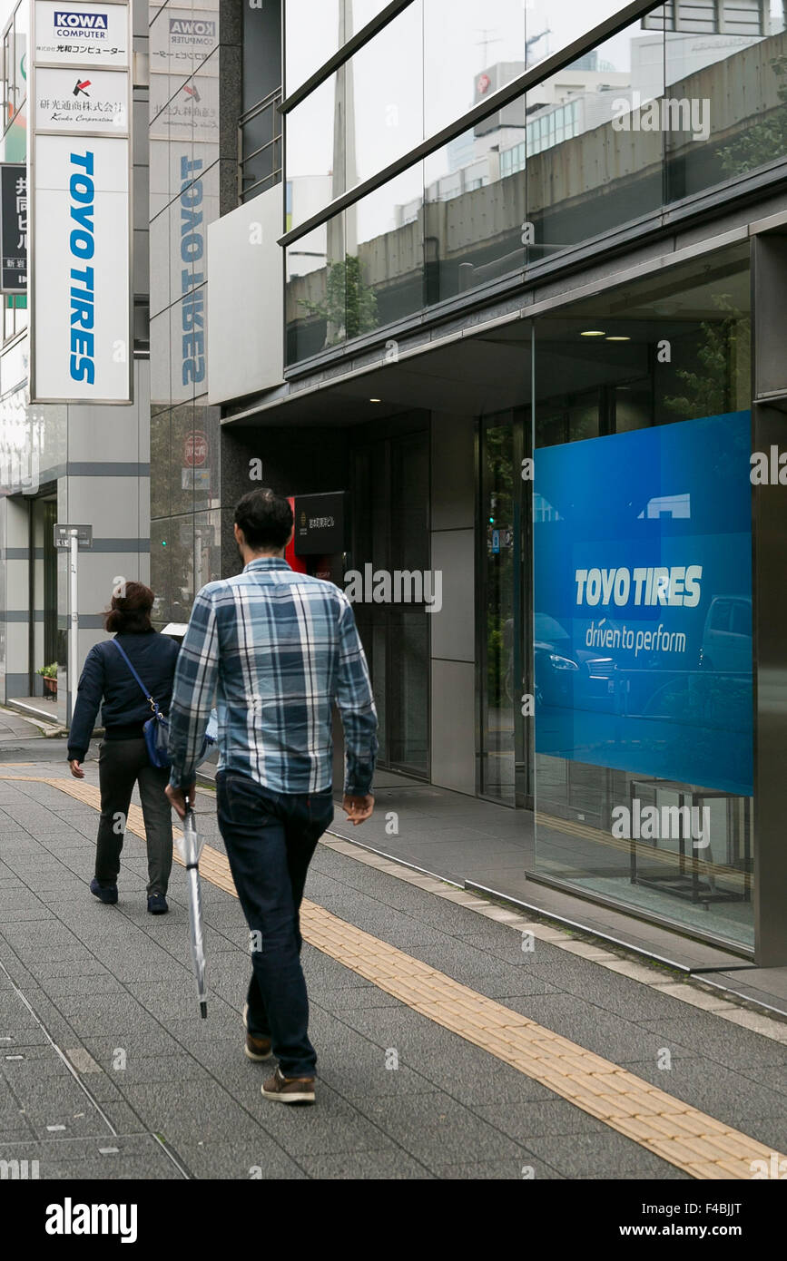 Pedestrians walk past the Toyo Tire & Rubber Co. building on October 16 ...