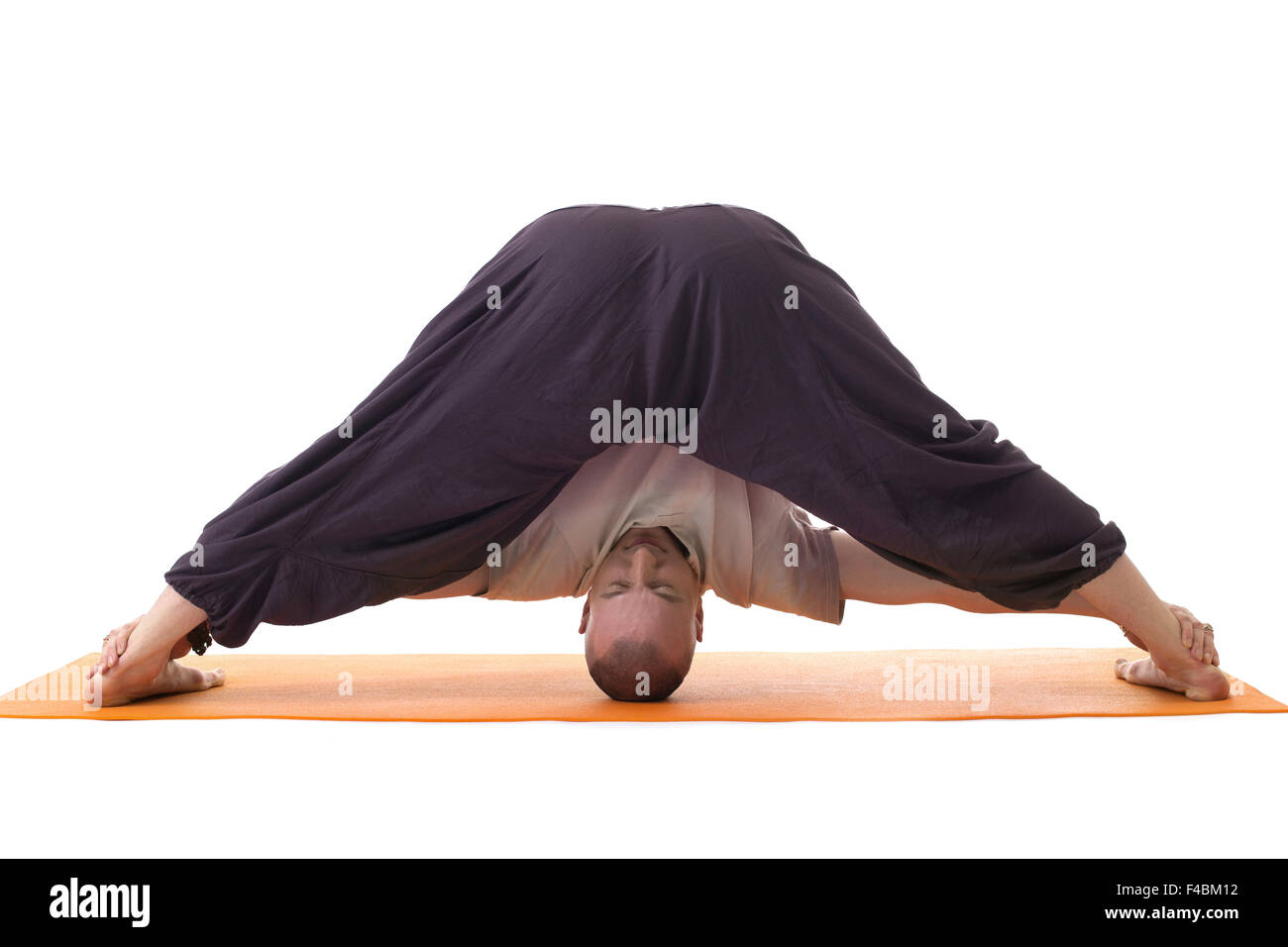 Relaxed man posing in difficult yoga pose Stock Photo - Alamy