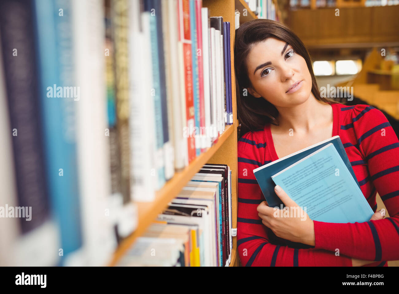 Portrait of young student holding books Stock Photo - Alamy