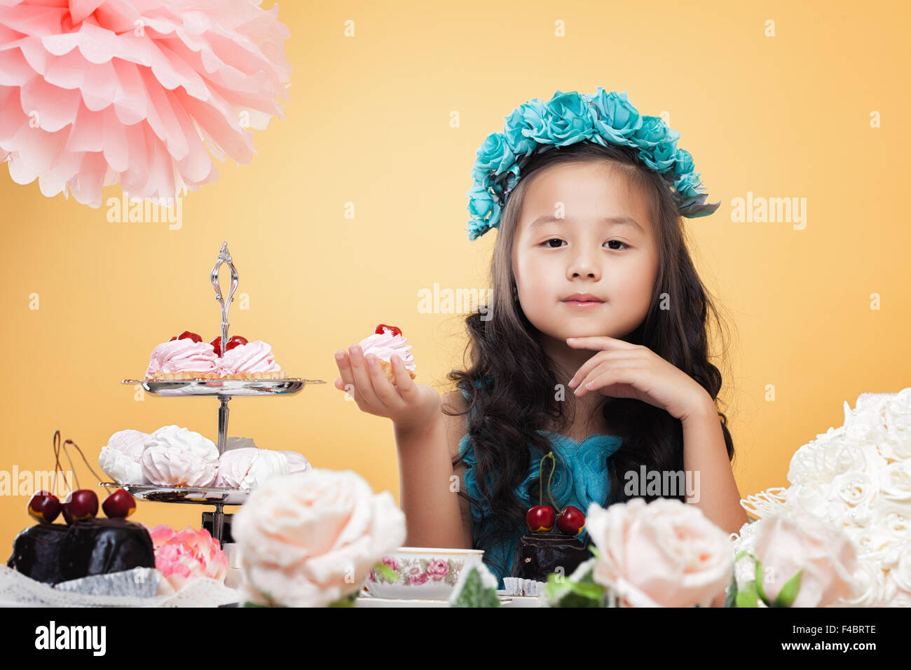 Lovely little girl posing while drinking tea Stock Photo - Alamy