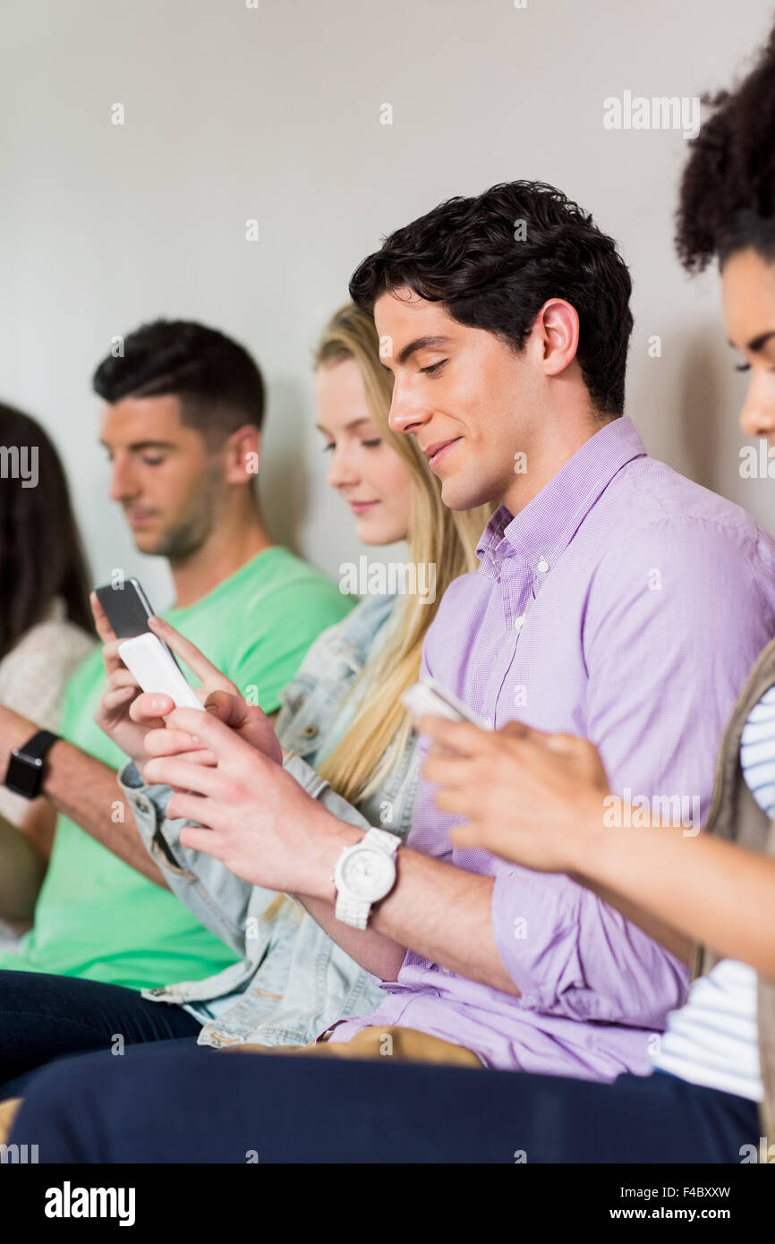 Students using their smartphones in a row Stock Photo - Alamy