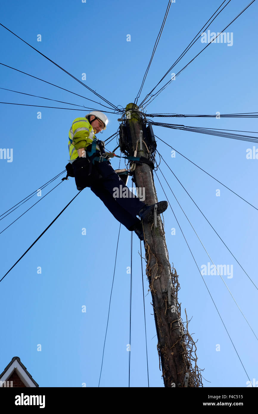 telecoms engineer working from telegraph pole uk Stock Photo - Alamy