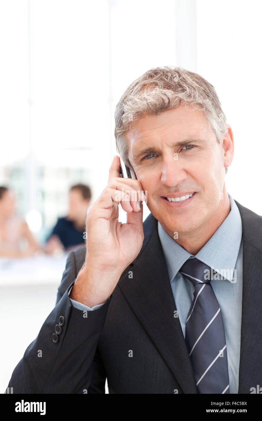 Businessman phoning while his team is working Stock Photo - Alamy