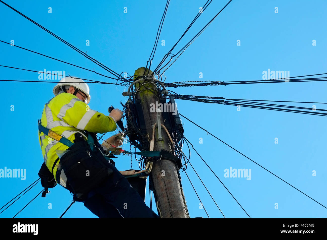 telecoms engineer working from telegraph pole uk Stock Photo - Alamy