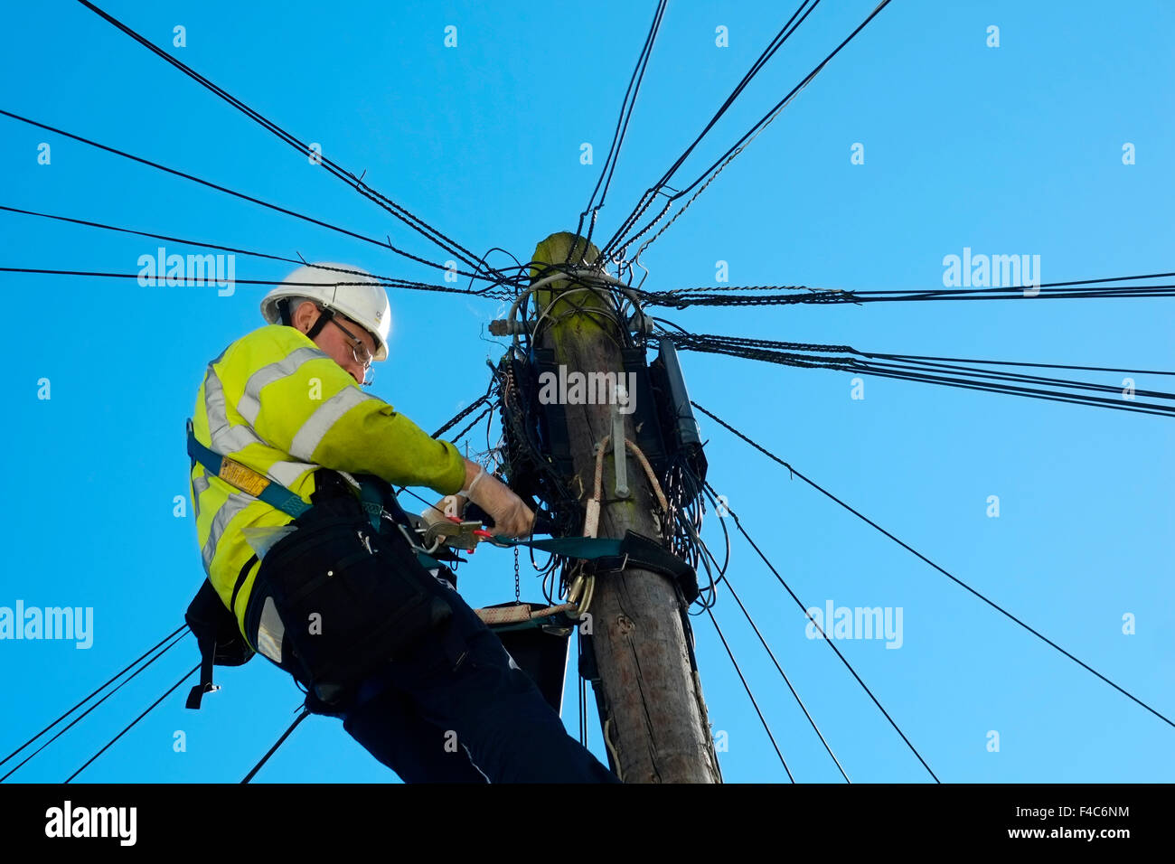 telecoms engineer working from telegraph pole uk Stock Photo - Alamy