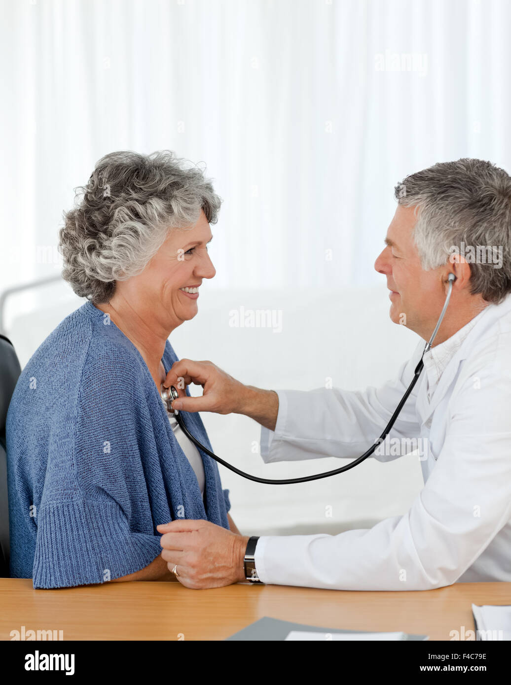 A senior doctor doing an examination of his patient Stock Photo - Alamy