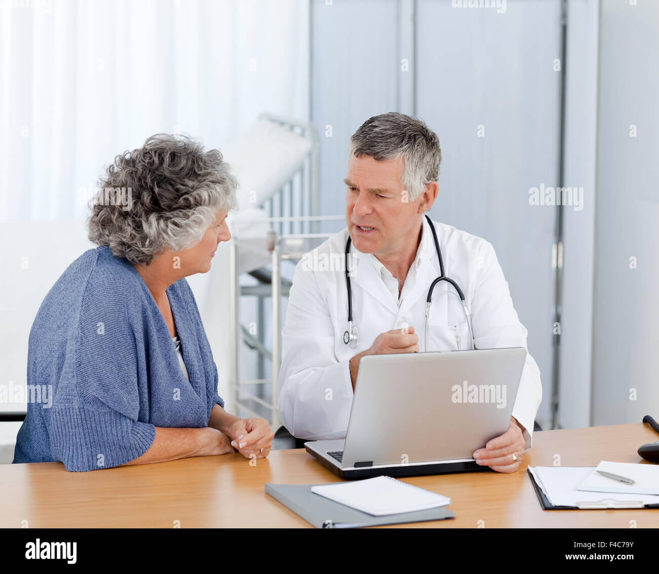 A senior doctor with his patient looking at the laptop Stock Photo - Alamy